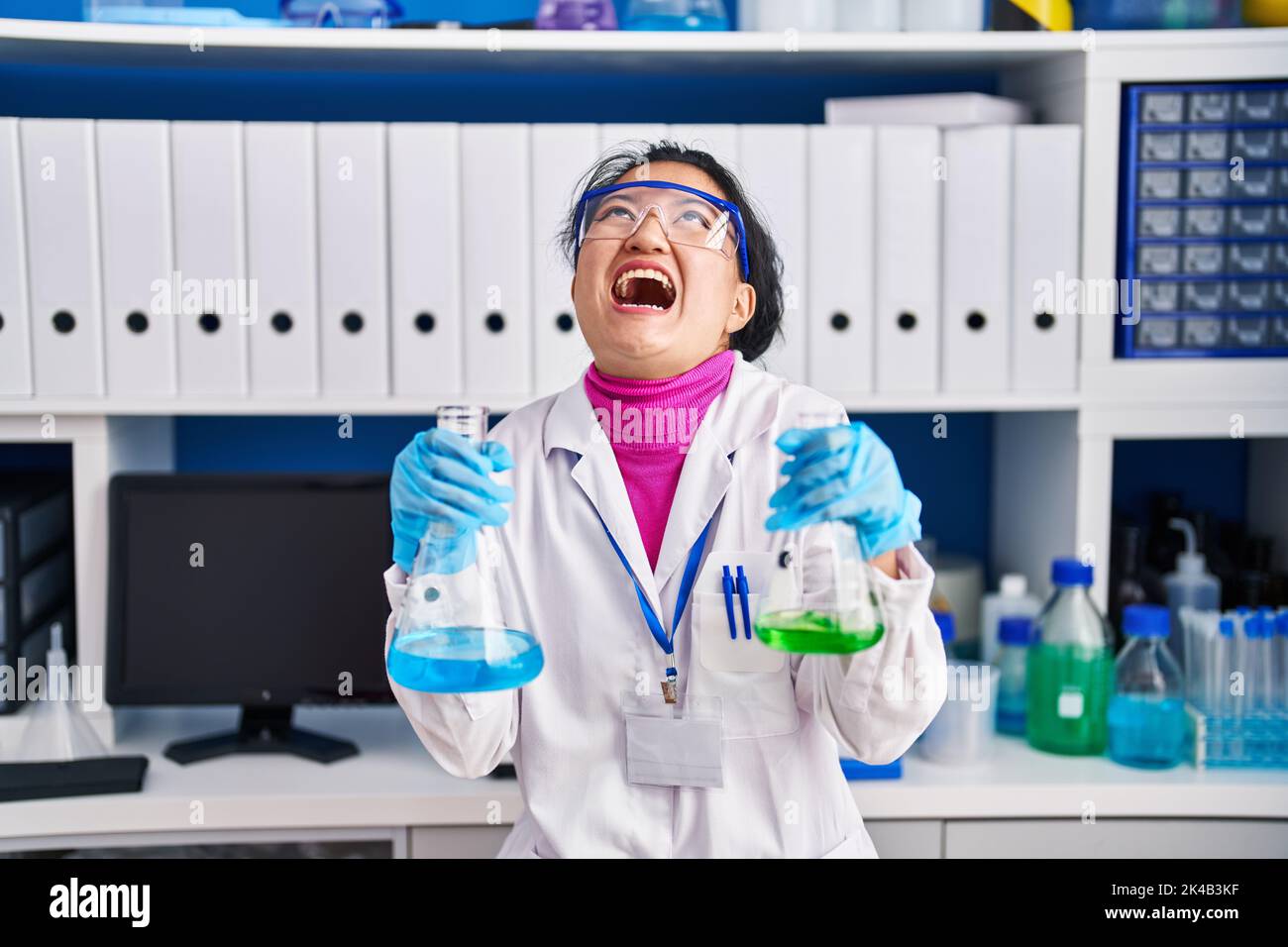 Young asian woman working at scientist laboratory angry and mad ...