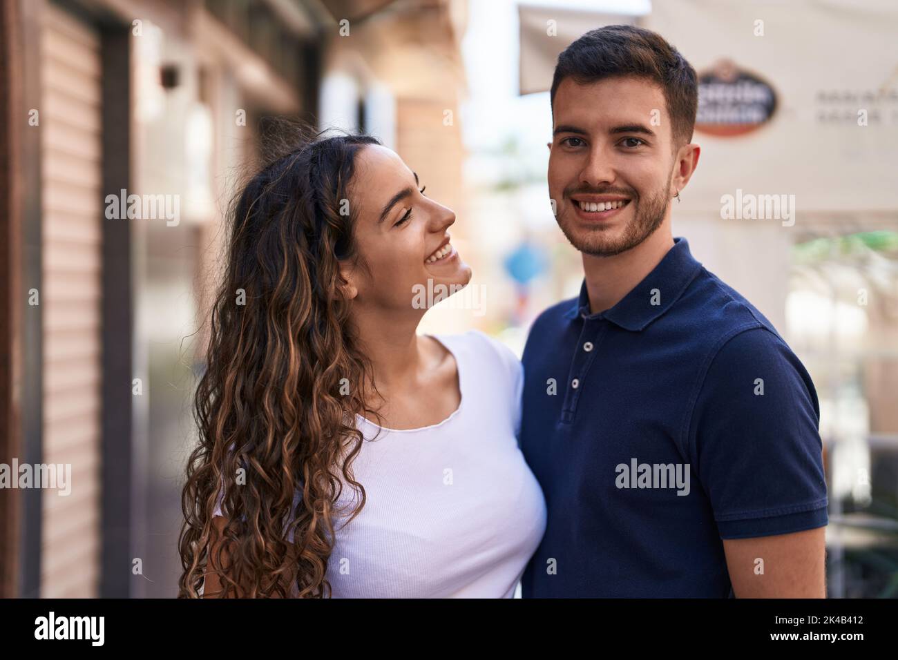 Young hispanic couple smiling confident hugging each other at street ...