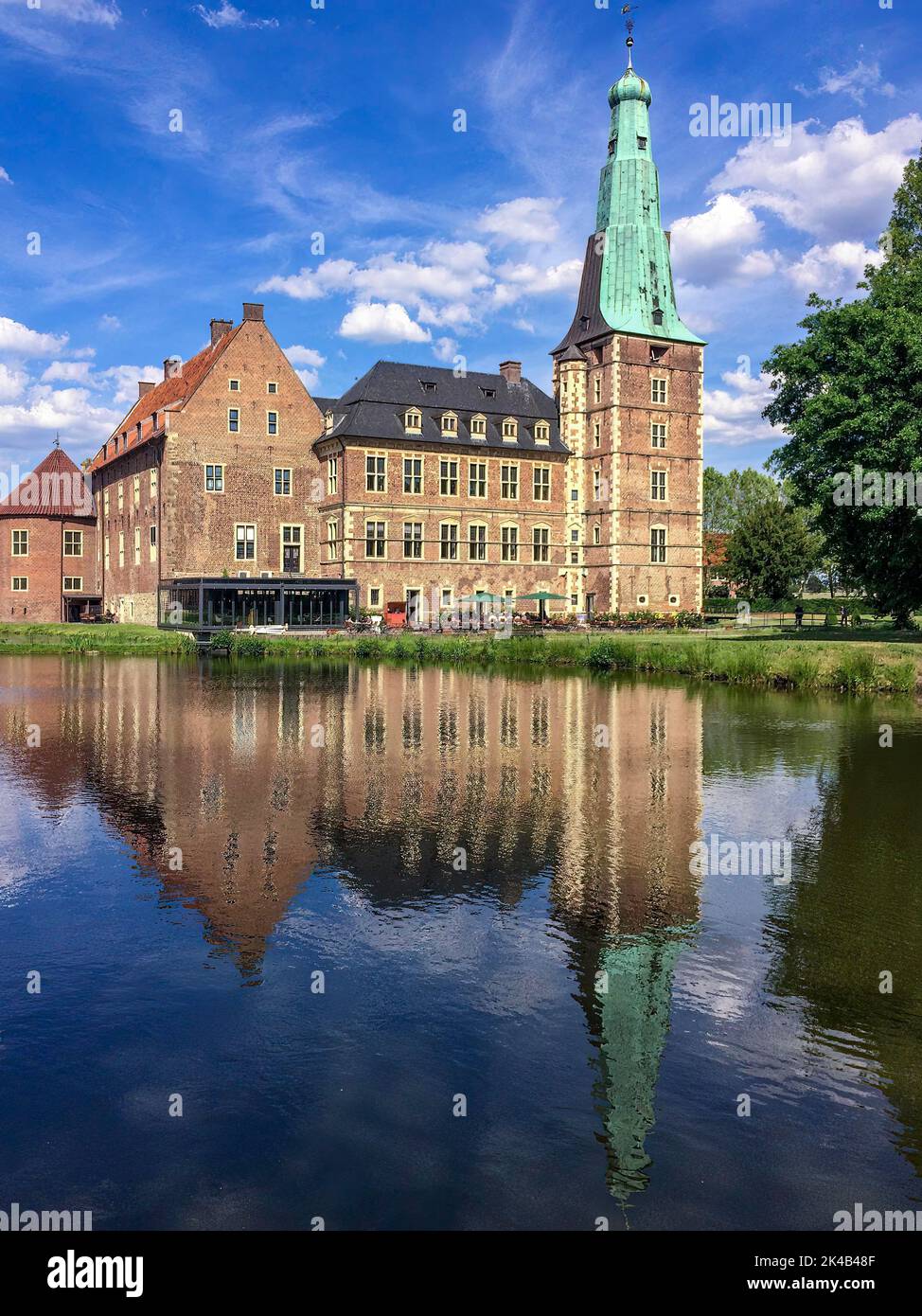 View over moat on moated castle Raesfeld, below reflection on water ...