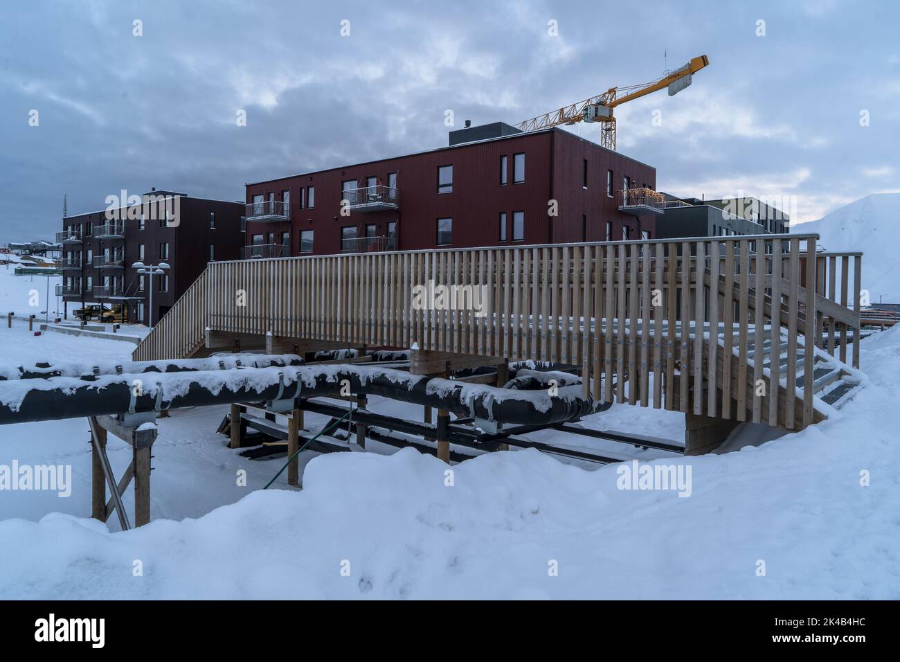 Residential apartment buildings and bridge over raised pipe lines ...