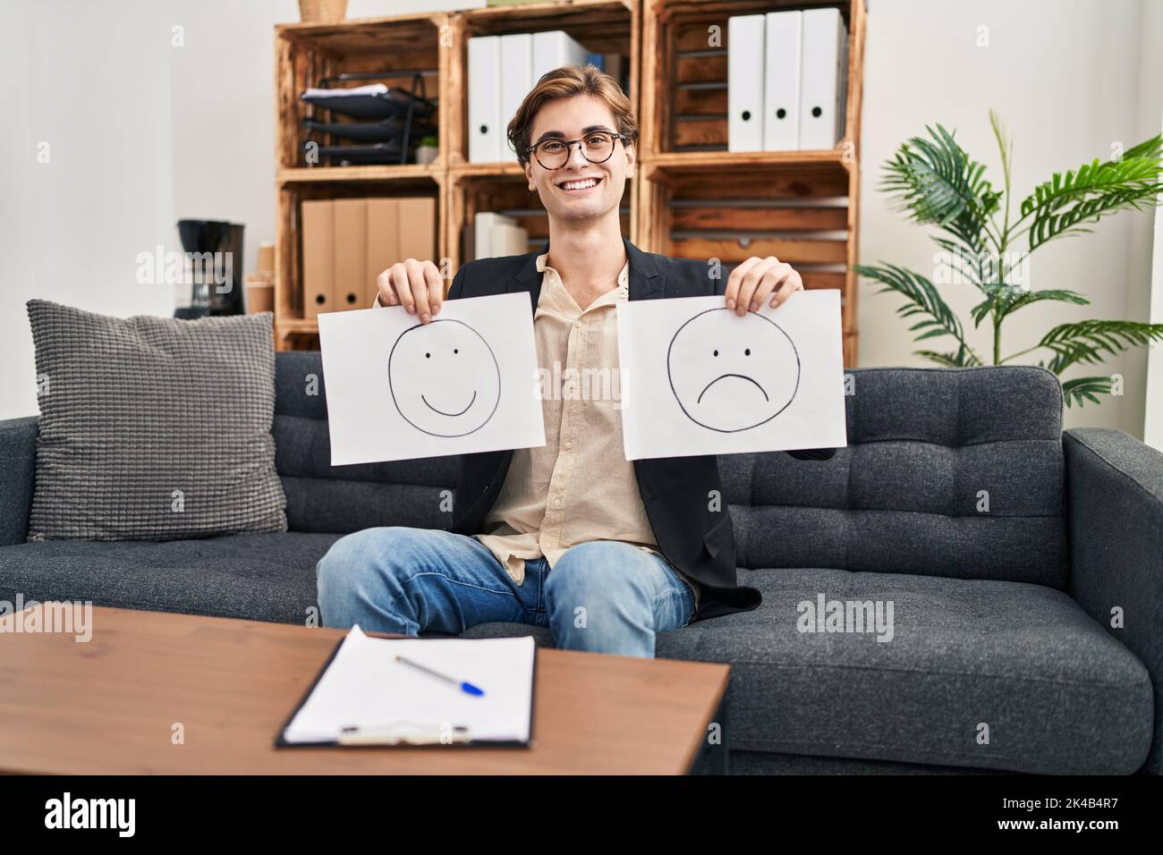 Young therapist man working on depression holding sad to happy emotion ...