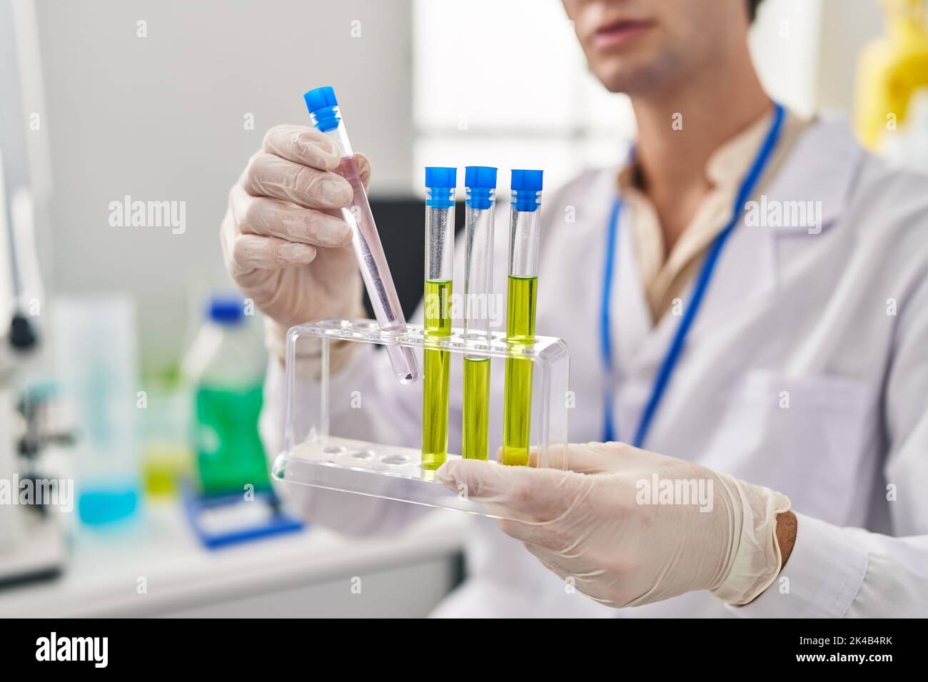 Young caucasian man scientist holding test tubes at laboratory Stock ...