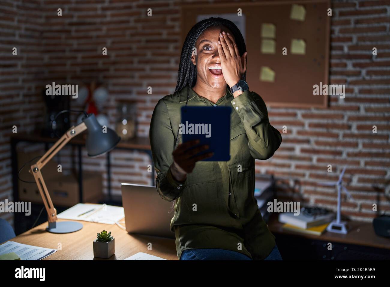 Young african american with braids working at the office at night ...