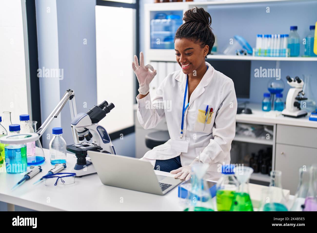 Young african american with braids working at scientist laboratory with ...