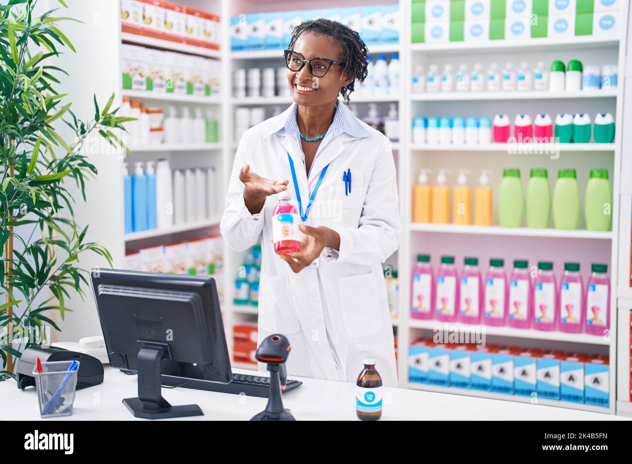 Middle age african american woman pharmacist holding baby medication ...