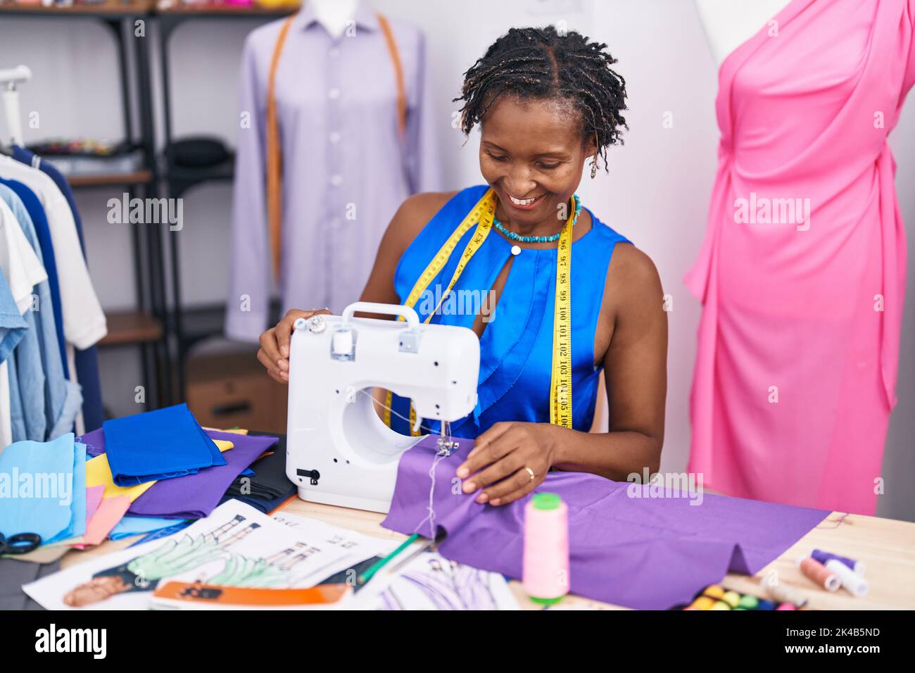 Middle age african american woman tailor smiling confident using sewing ...