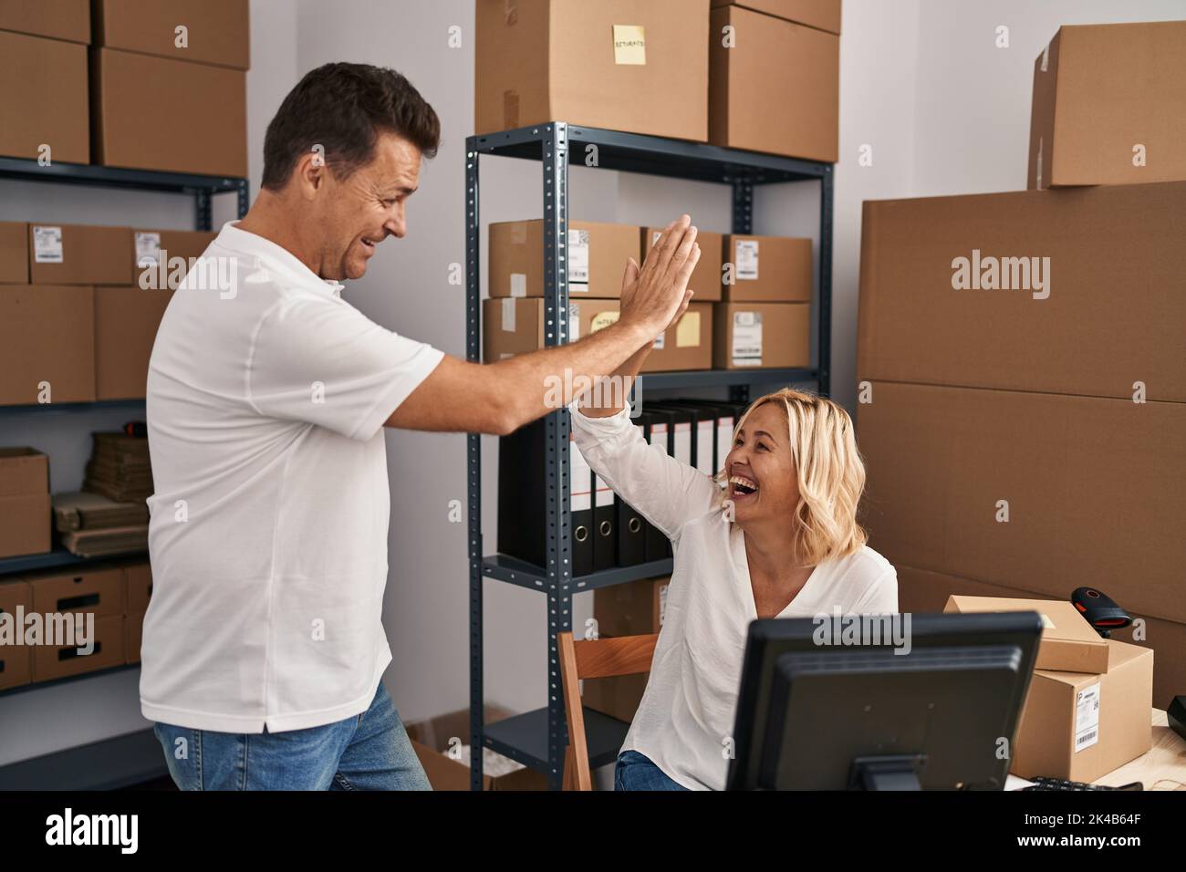 Middle age man and woman business partners cheerful high five with ...