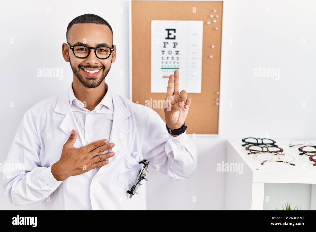 African american optician man standing by eyesight test smiling ...