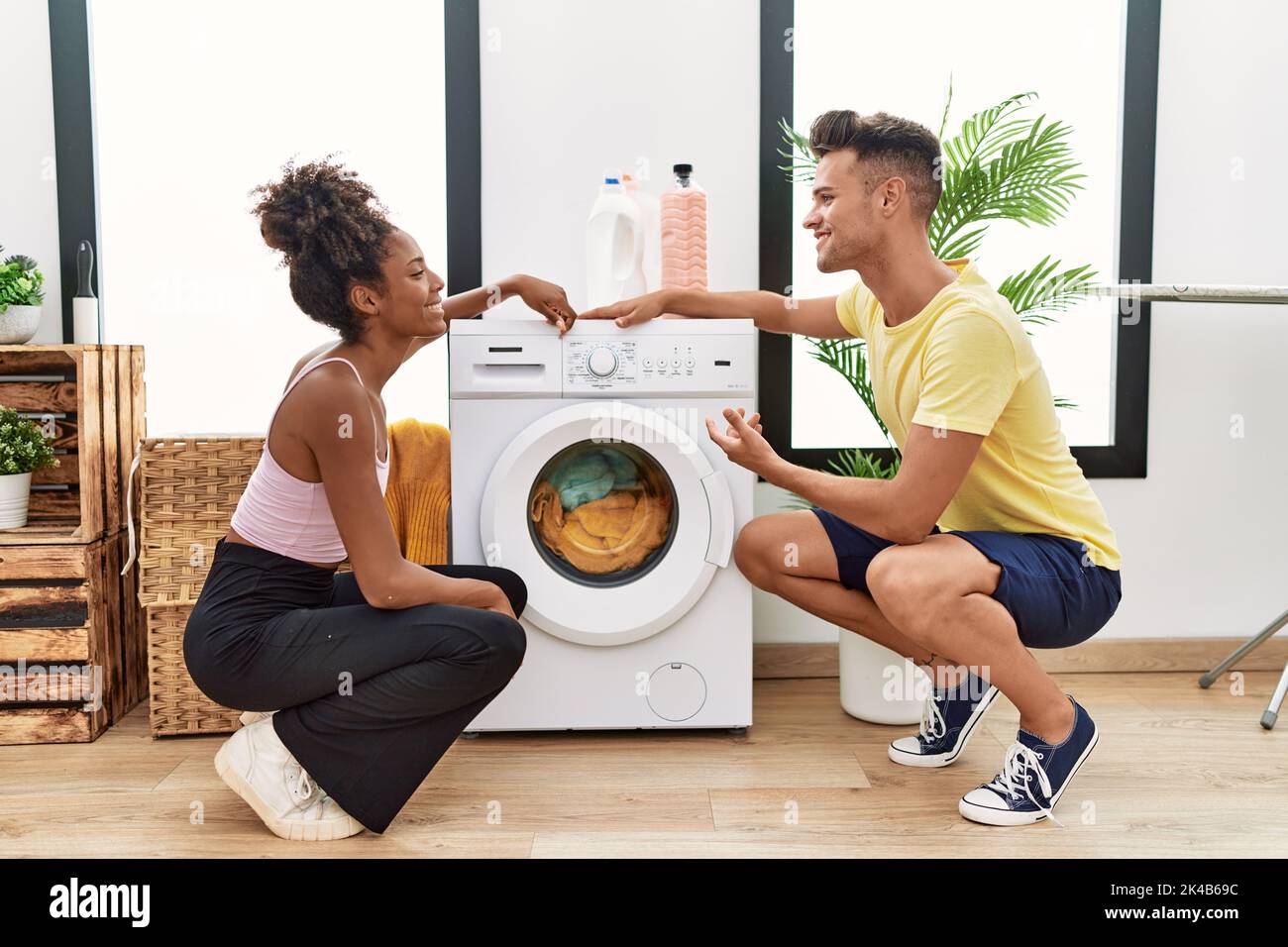Man and woman couple smiling confident turn on washing machine at ...