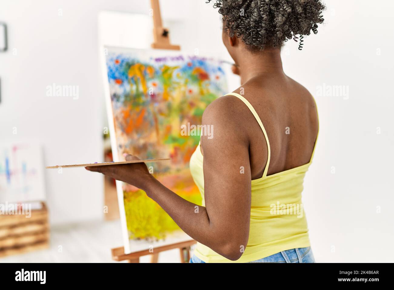 Young african american artist woman on back view drawing at art studio ...