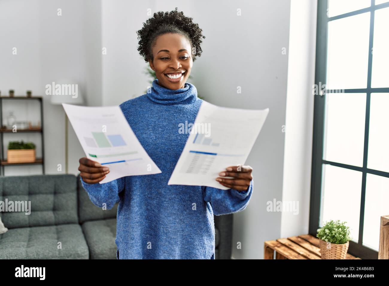 African american woman reading document standing at home Stock Photo ...