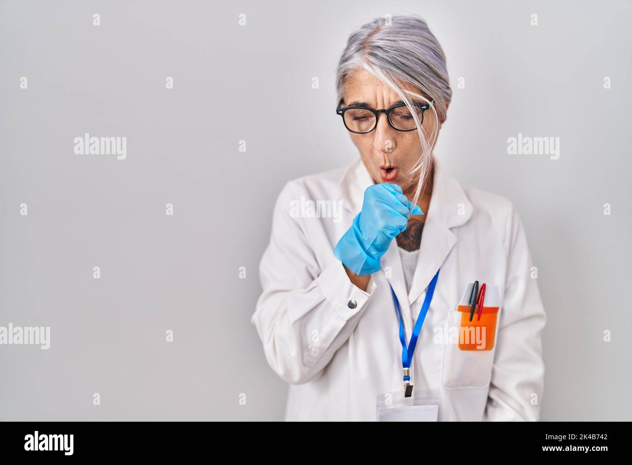 Middle age woman with grey hair wearing scientist robe feeling unwell ...