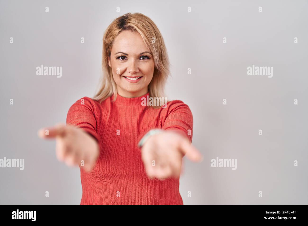 Blonde woman standing over isolated background smiling cheerful ...