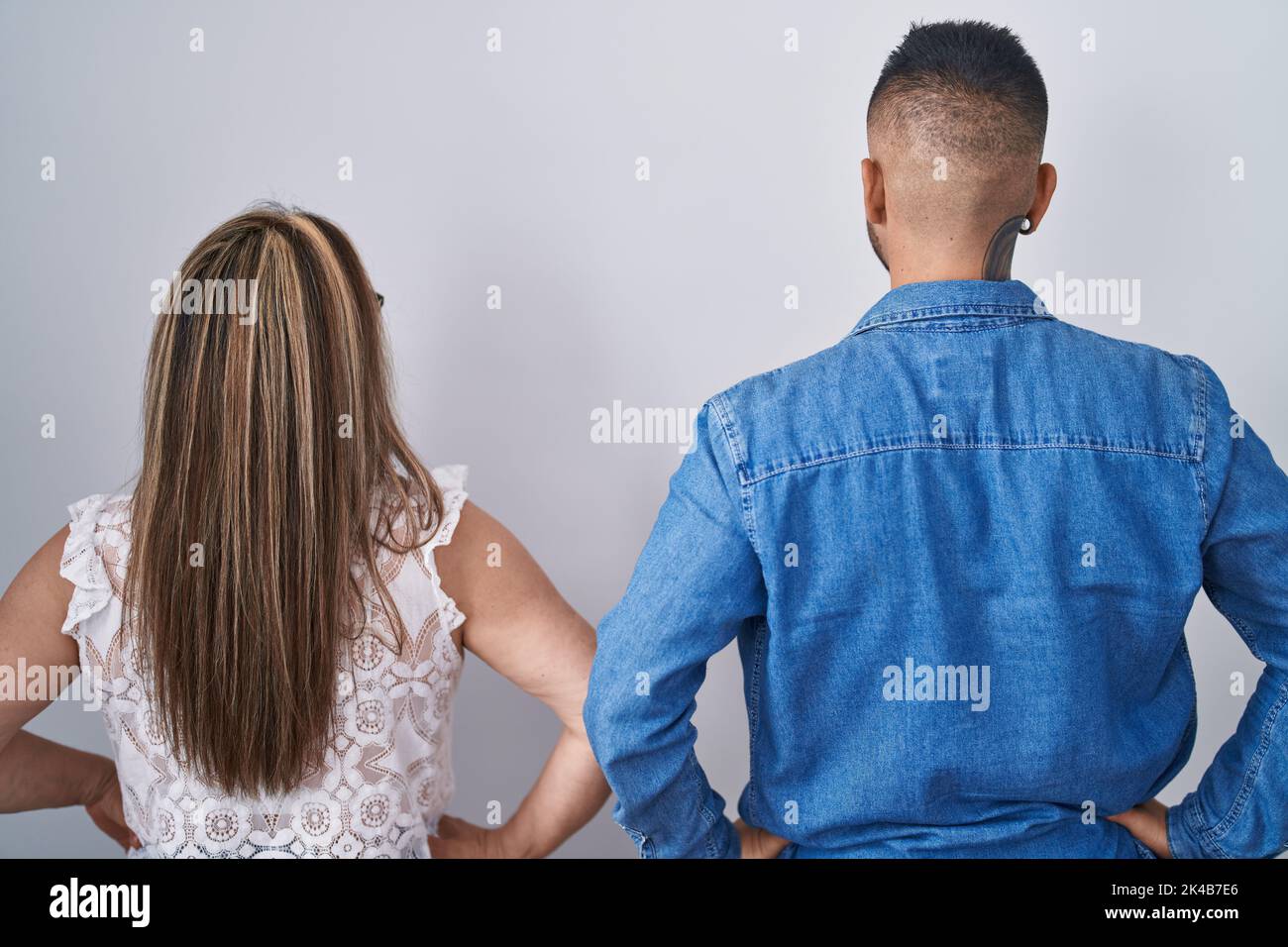 Hispanic mother and son standing together standing backwards looking ...