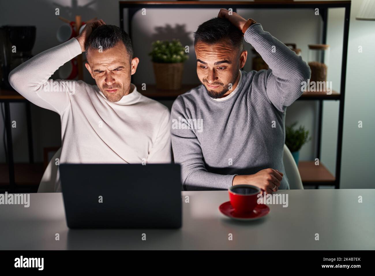 Homosexual couple using computer laptop confuse and wondering about ...