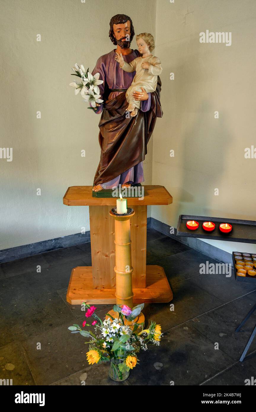 St. Joseph with baby Jesus, floral decorations and offering candles ...