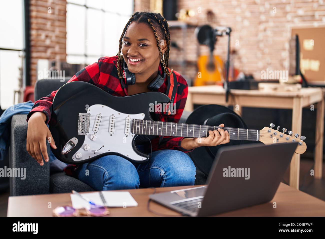 African american woman musician having online electrical guitar lesson ...