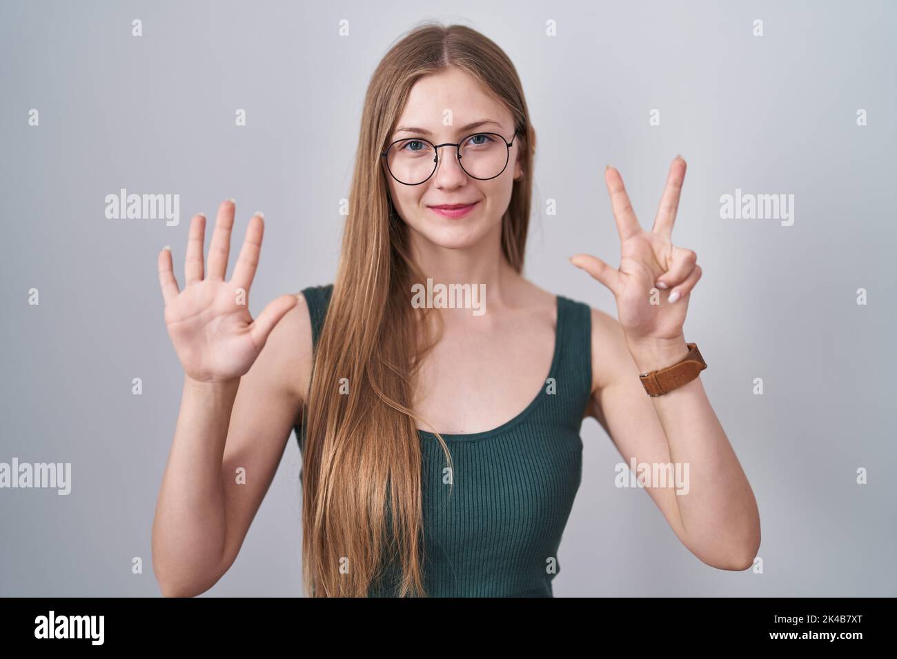 Young caucasian woman standing over white background showing and ...