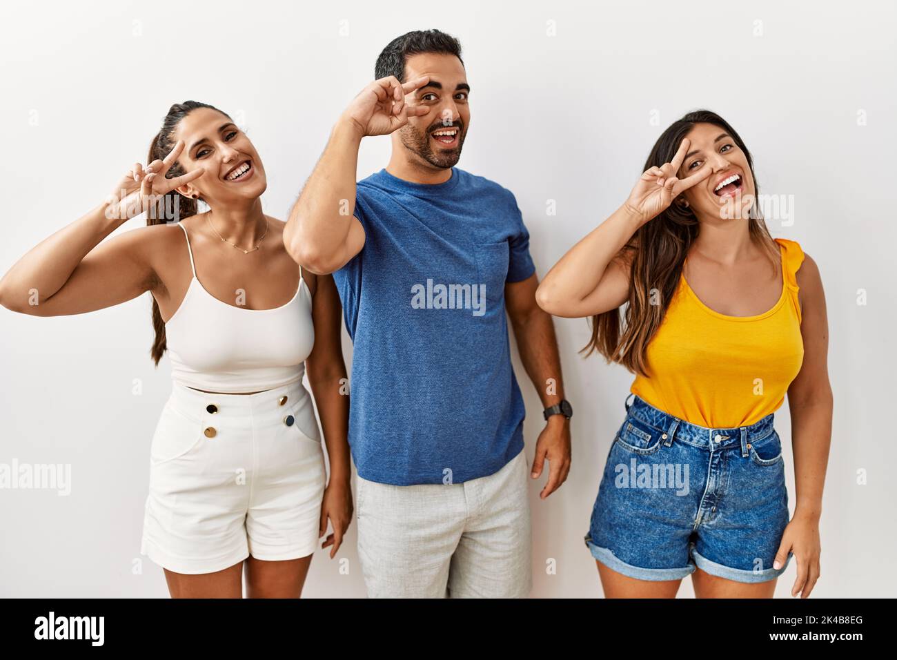 Group of young hispanic people standing over isolated background doing ...