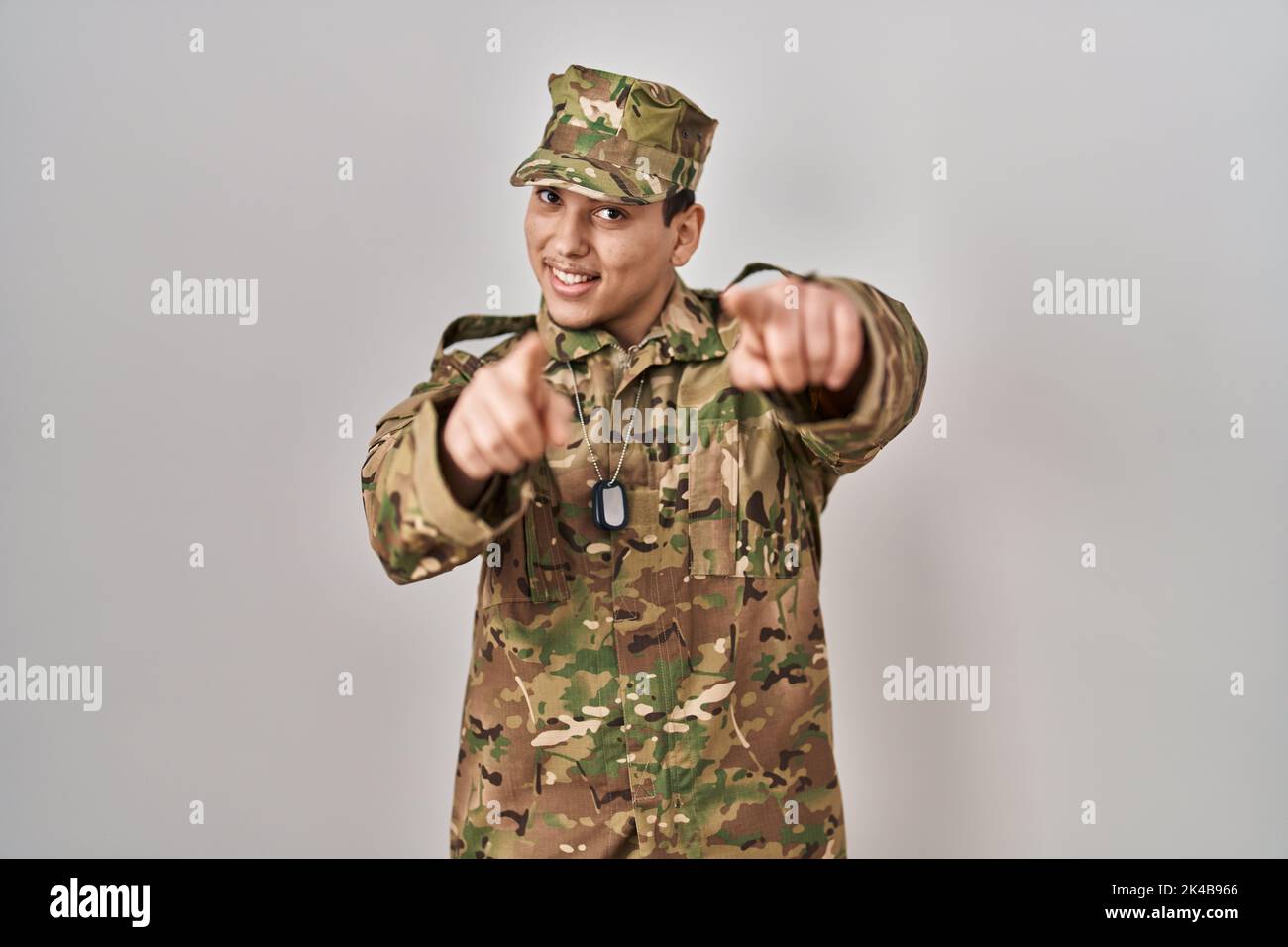 Young arab man wearing camouflage army uniform pointing to you and the ...