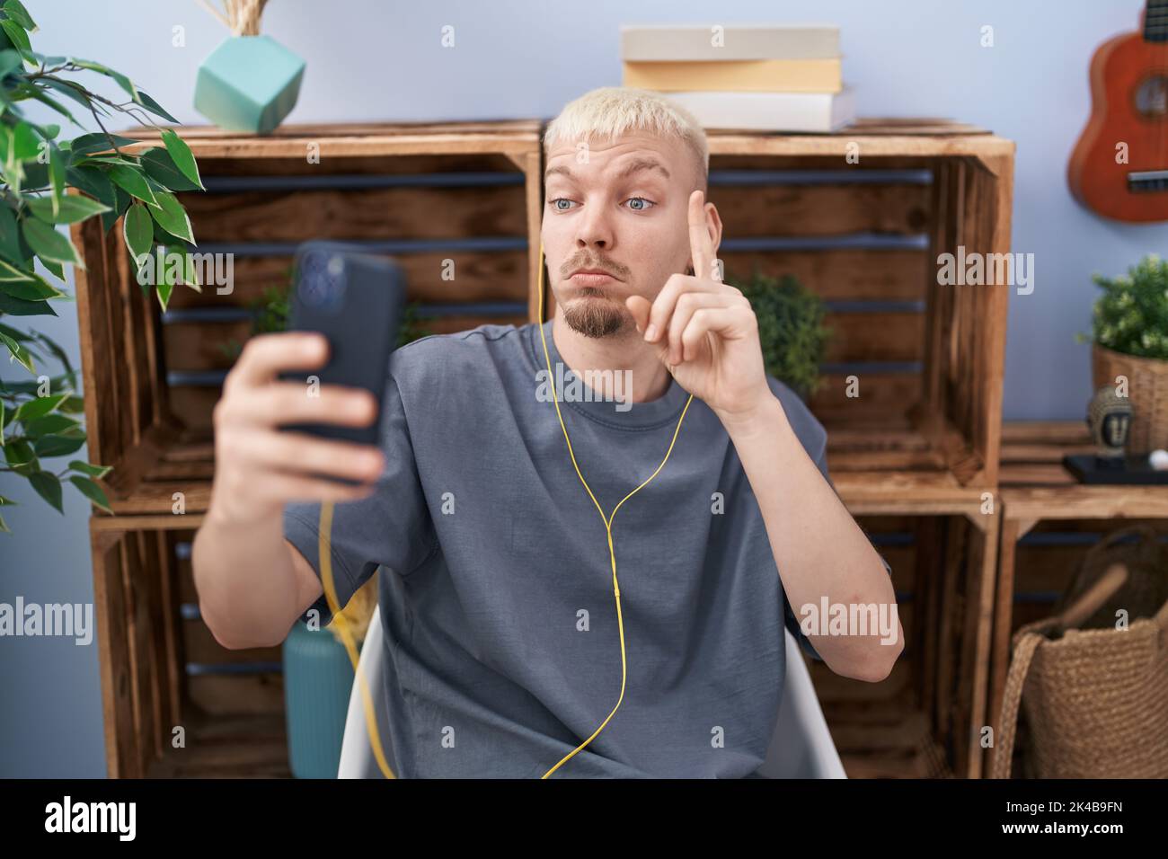 Young caucasian man doing video call with smartphone smiling with an ...