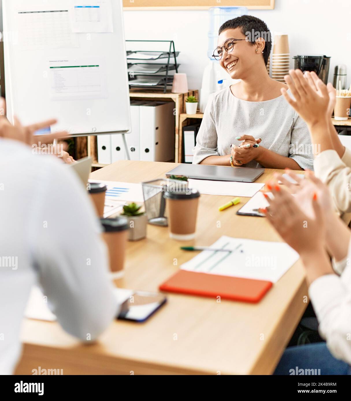 Group of business workers smiling and clapping to partner at the office ...