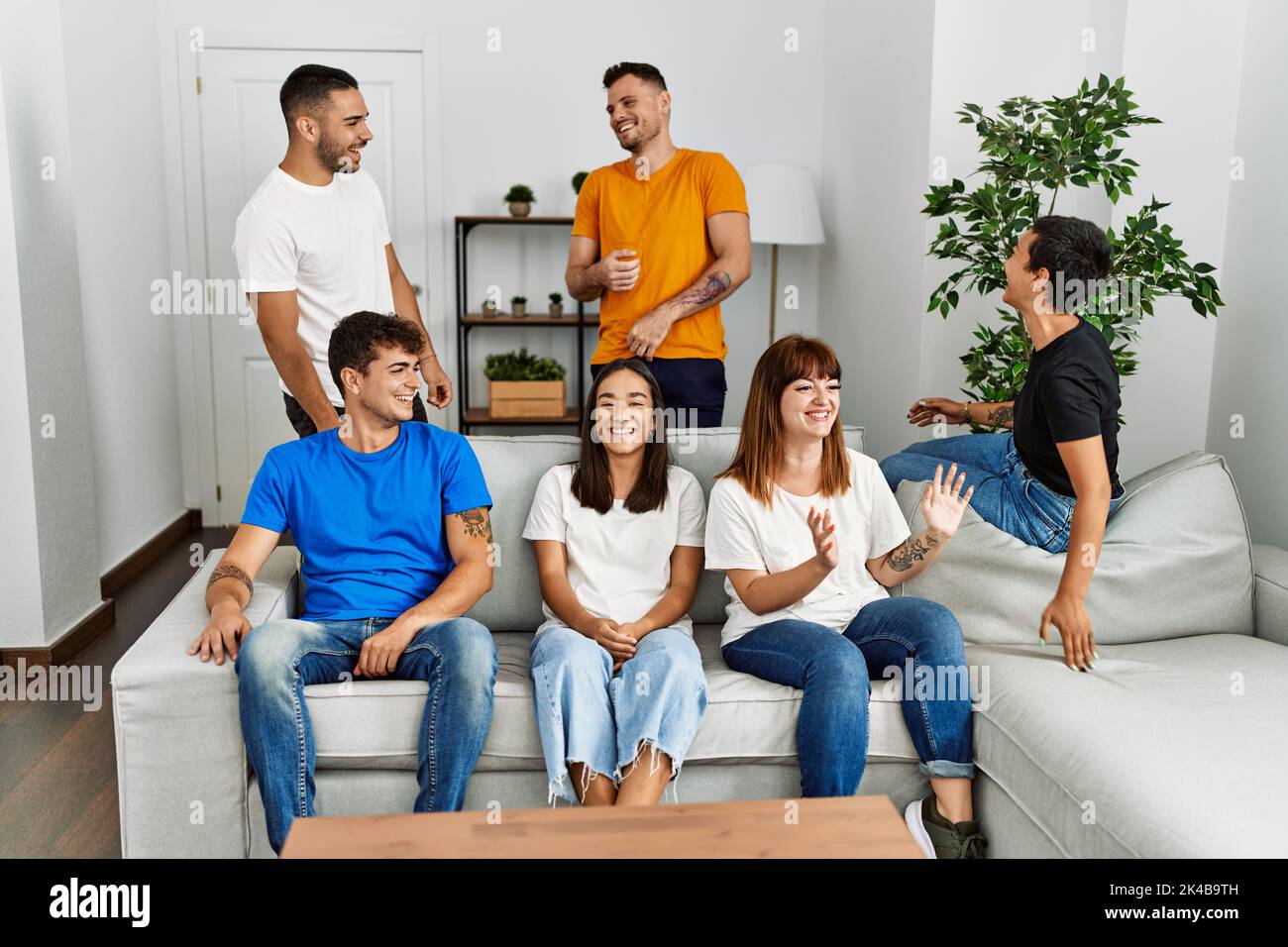 Group of young friends smiling happy sitting on the sofa at home Stock ...