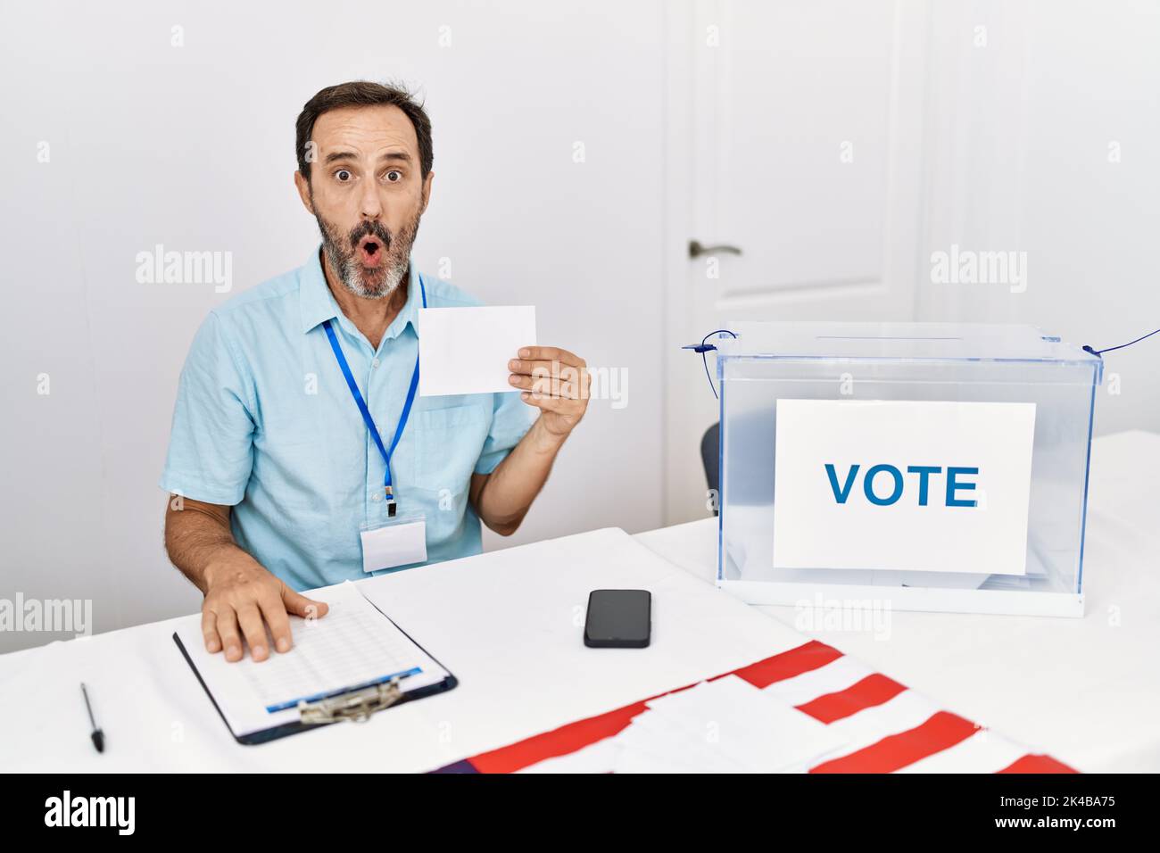 Middle age man with beard voting putting envelop in ballot box scared ...