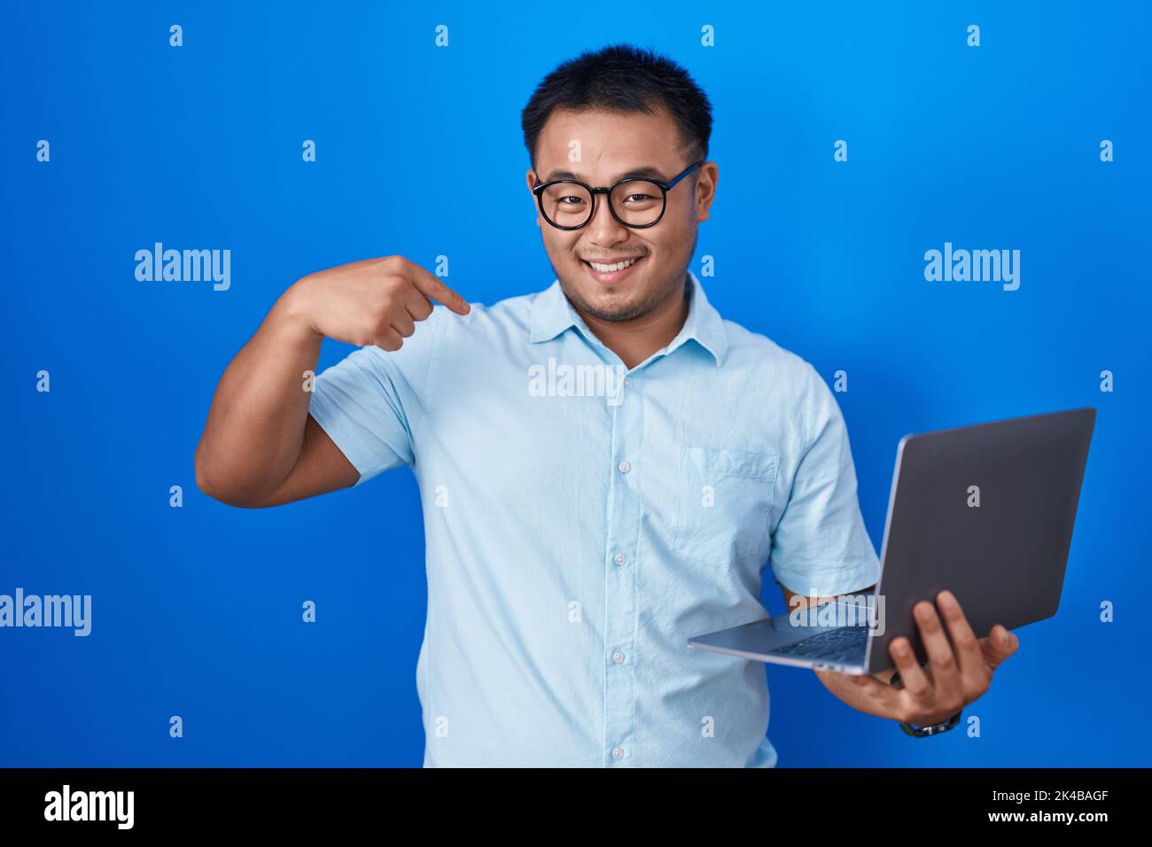 Chinese young man using computer laptop looking confident with smile on ...