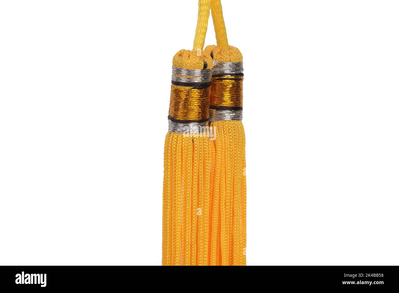 A fragment of two golden silk tassels. Isolated on a white background ...