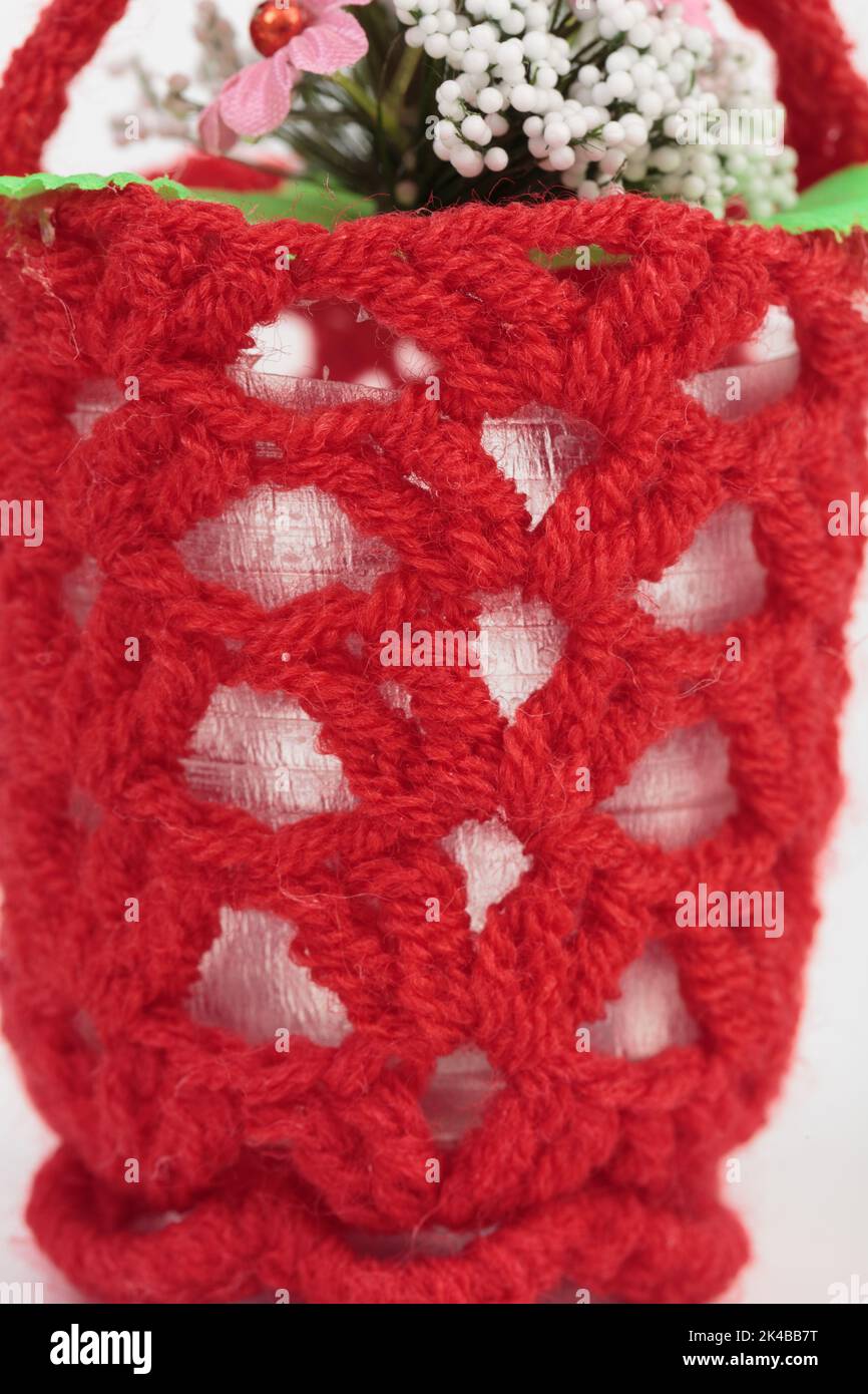 A flower pot in a knitted cover. It occupies the entire surface of the ...