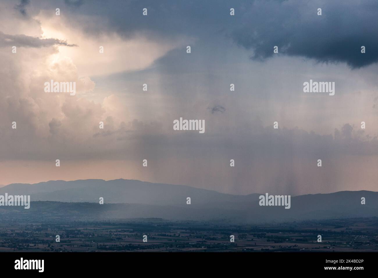 Rain and mist between valley and layers of mountains and hills beneath ...