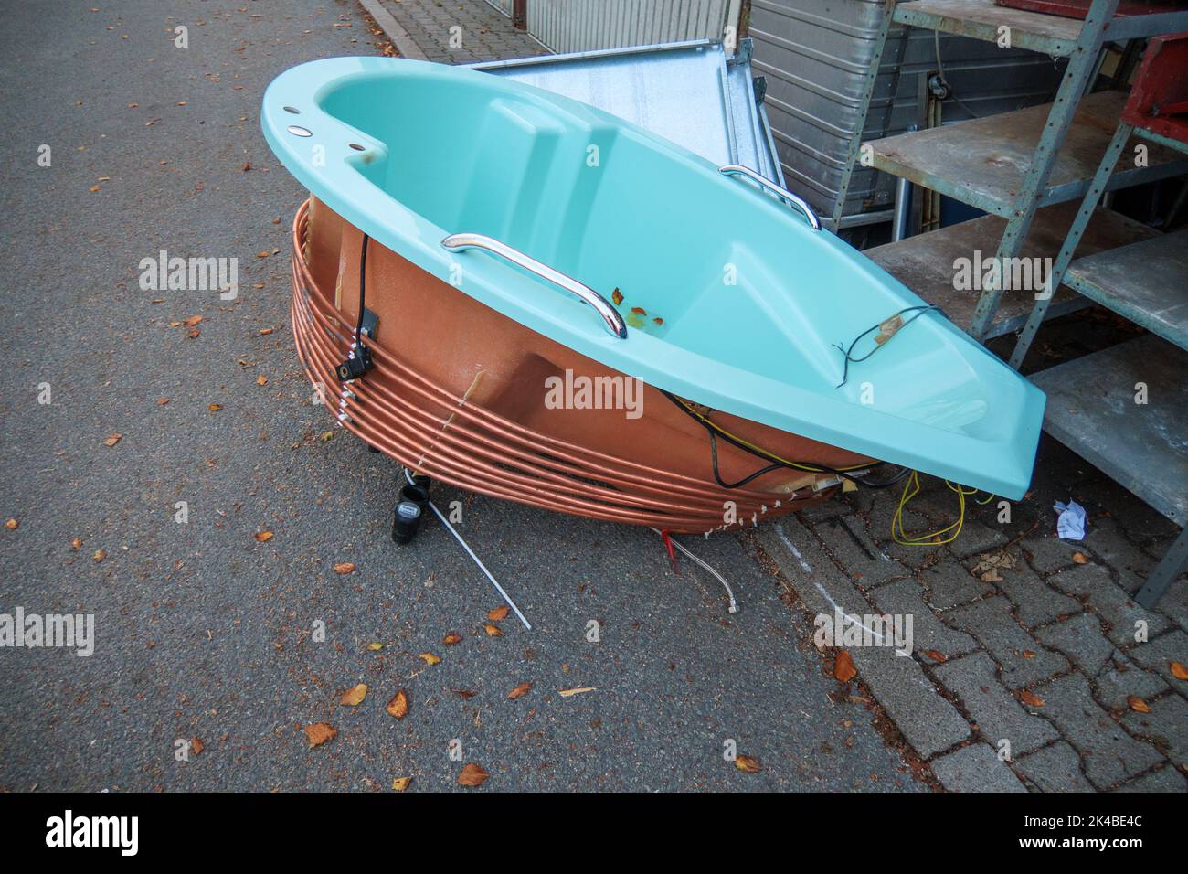 on the garbage lies a big discarded bathtub surrounded with copper ...