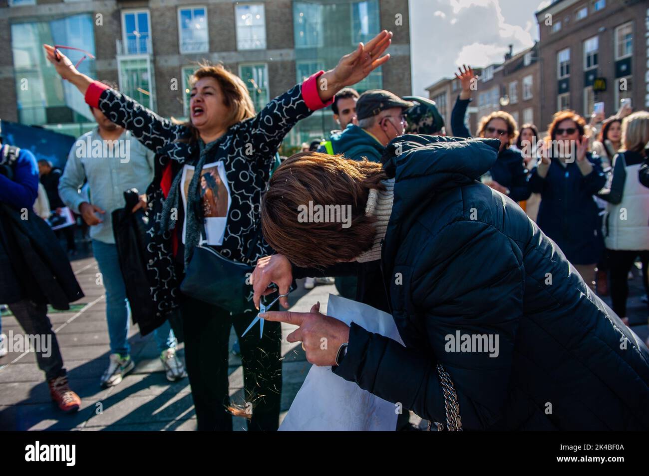 An Iranian woman is seen cutting off her hair during the demonstration ...