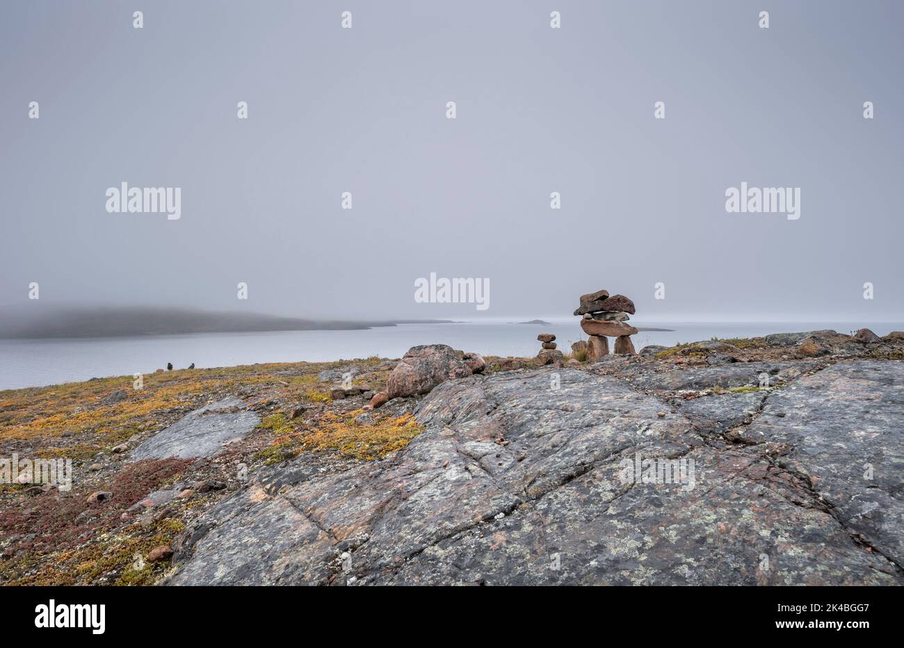 Inuksuk (Inukshuk) on a rock above the Arctic Ocean at Apex, Nunavut ...