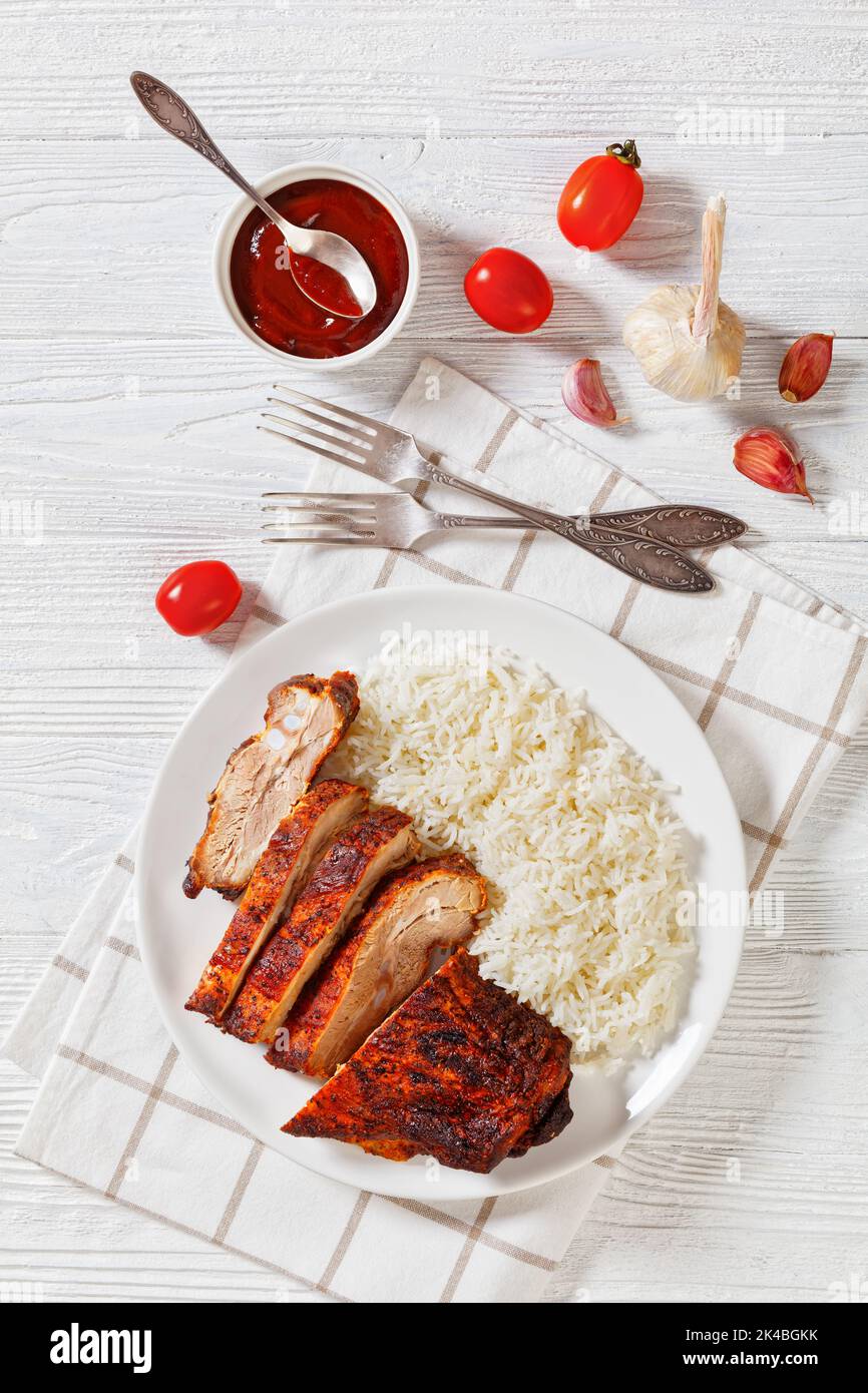 roast baby back pork meaty ribs with basmati rice on plate on white ...