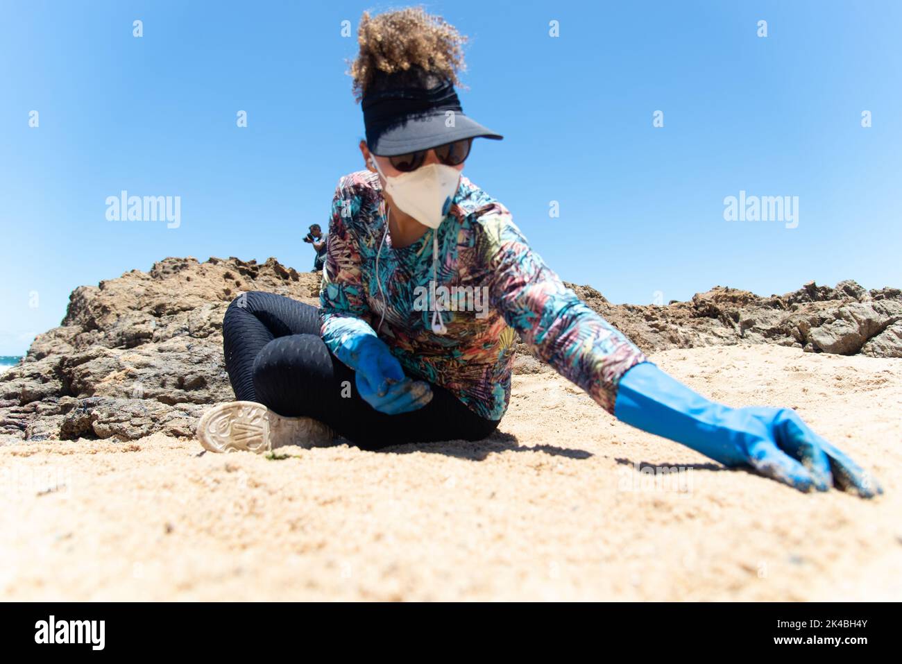 Volunteers clean up oil at Rio Vermelho beach in the city of Salvador ...