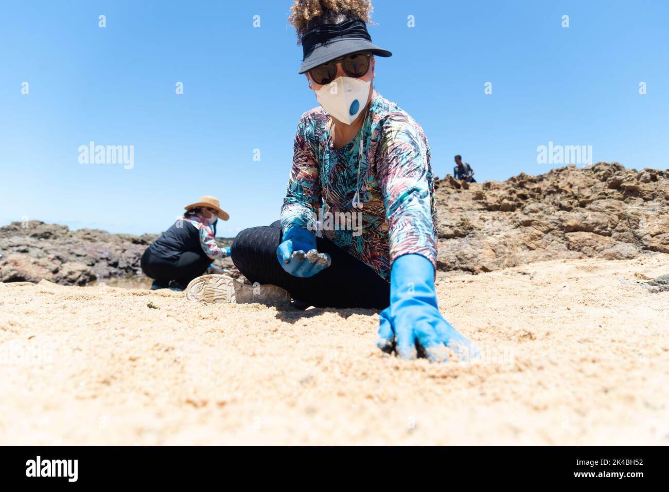 Volunteers clean up oil at Rio Vermelho beach in the city of Salvador ...
