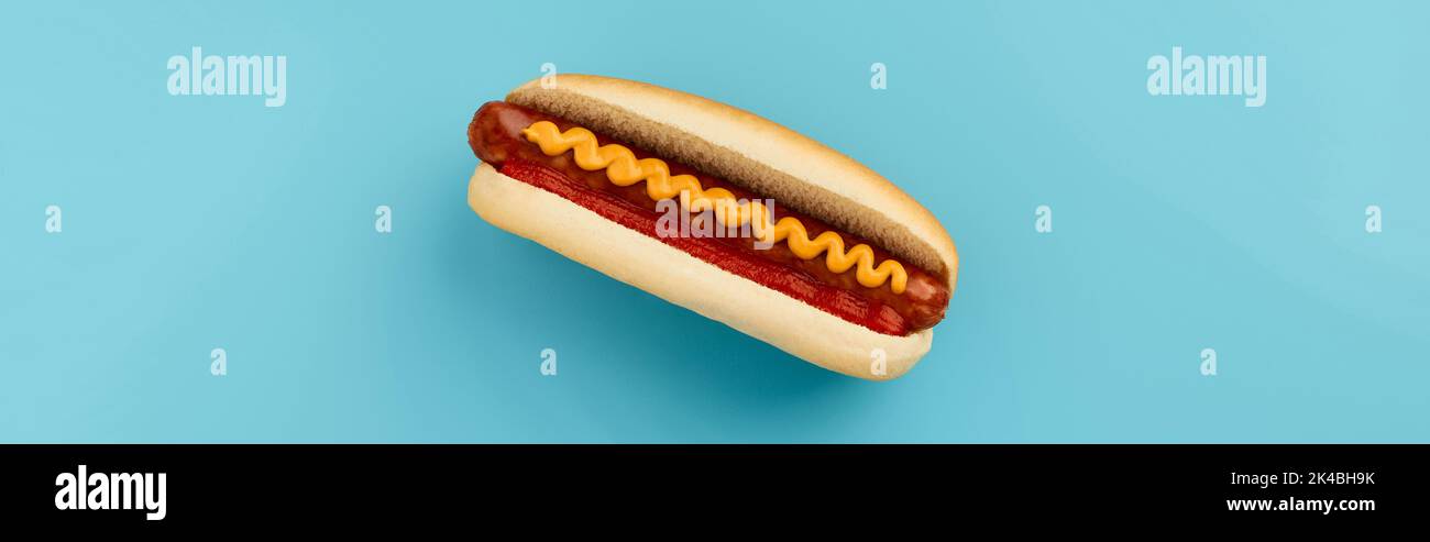 Classic hot dog with wurst, ketchup and mustard on blue background ...