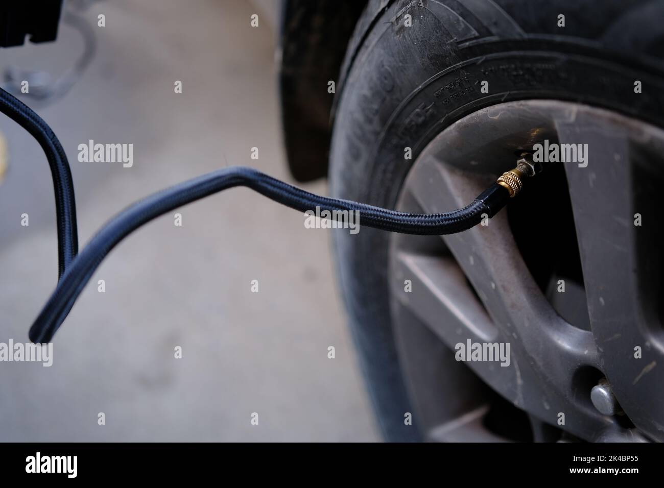 Inflating car tire with portable air pump outdoors Stock Photo - Alamy