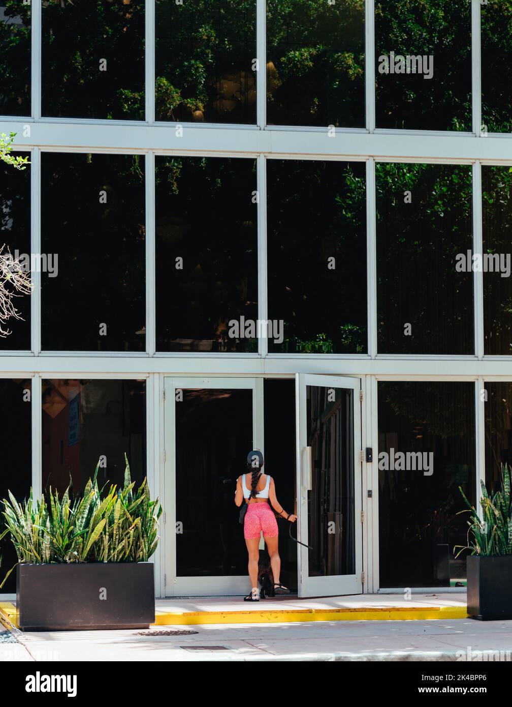 A vertical back shot of a female opening the door of a building Stock ...