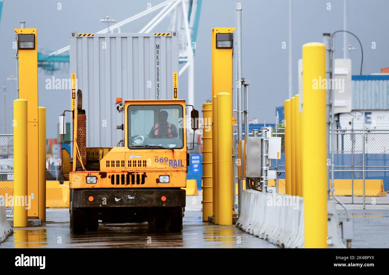 A shipping container pulled by a port vehicle arrives for scanning by ...