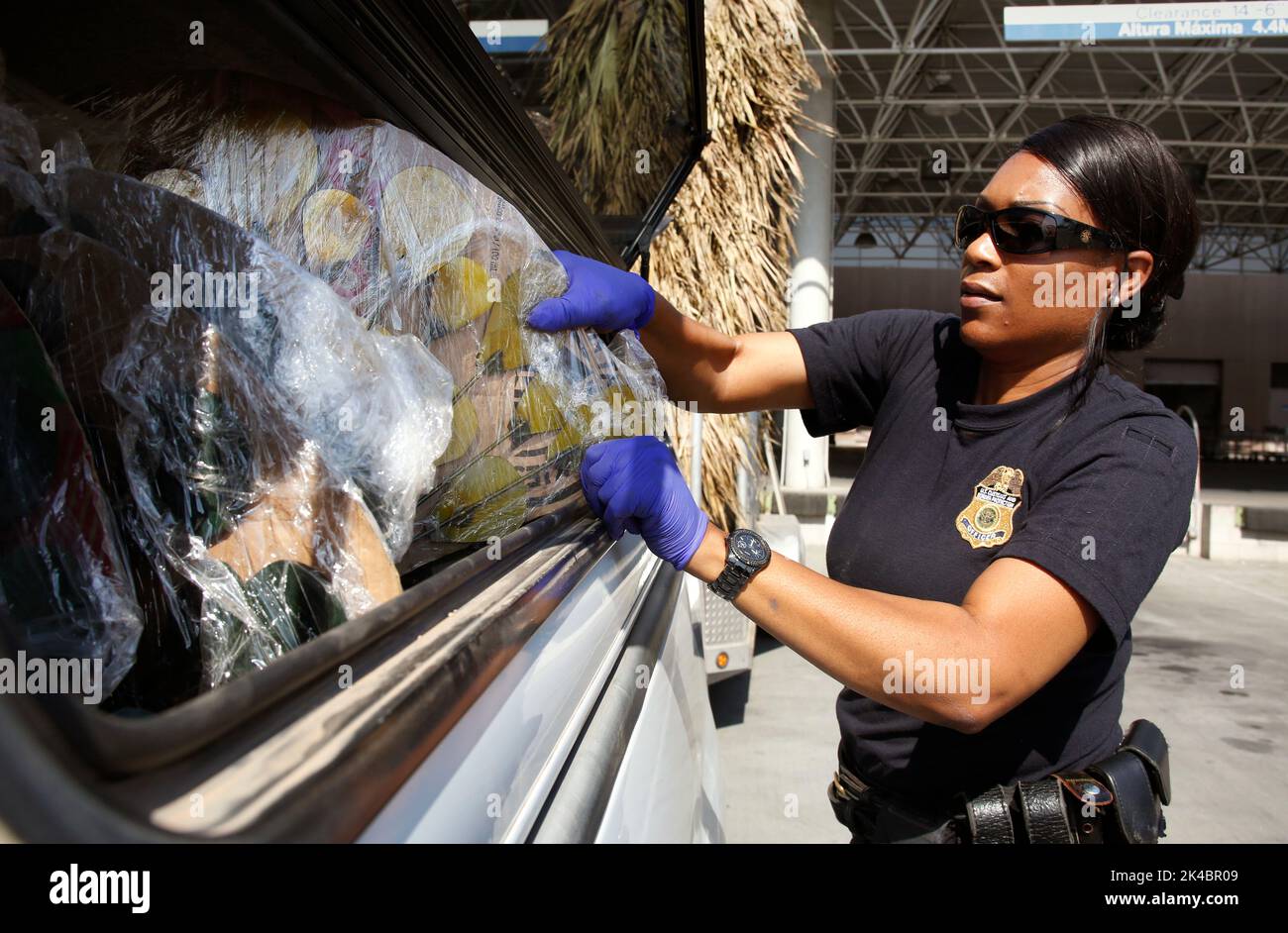 U.S. Customs and Border Protection officer reaches into the window of a ...