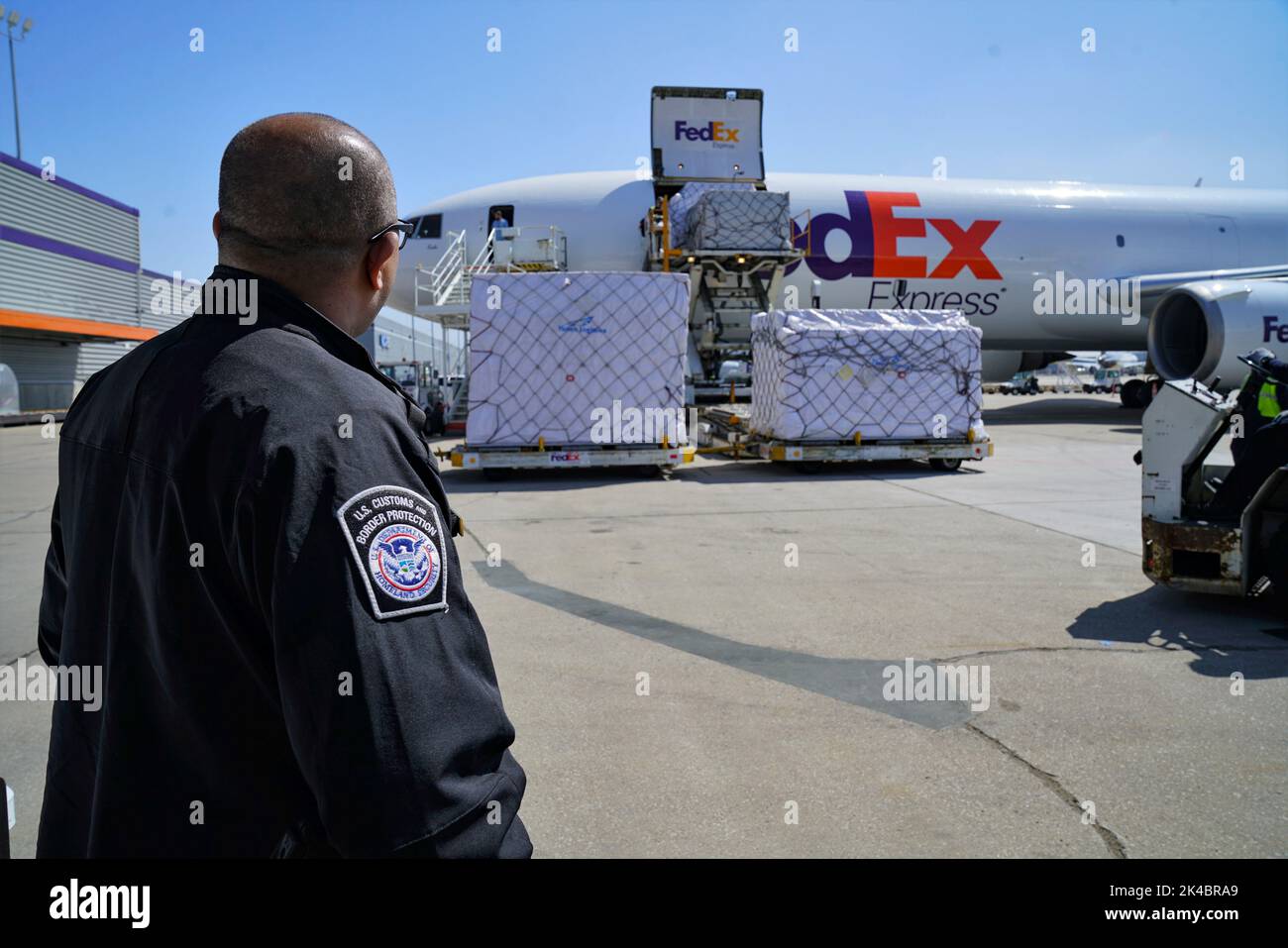 A CBP Office of Field Operation ofﬁcer monitors the delivery of ...