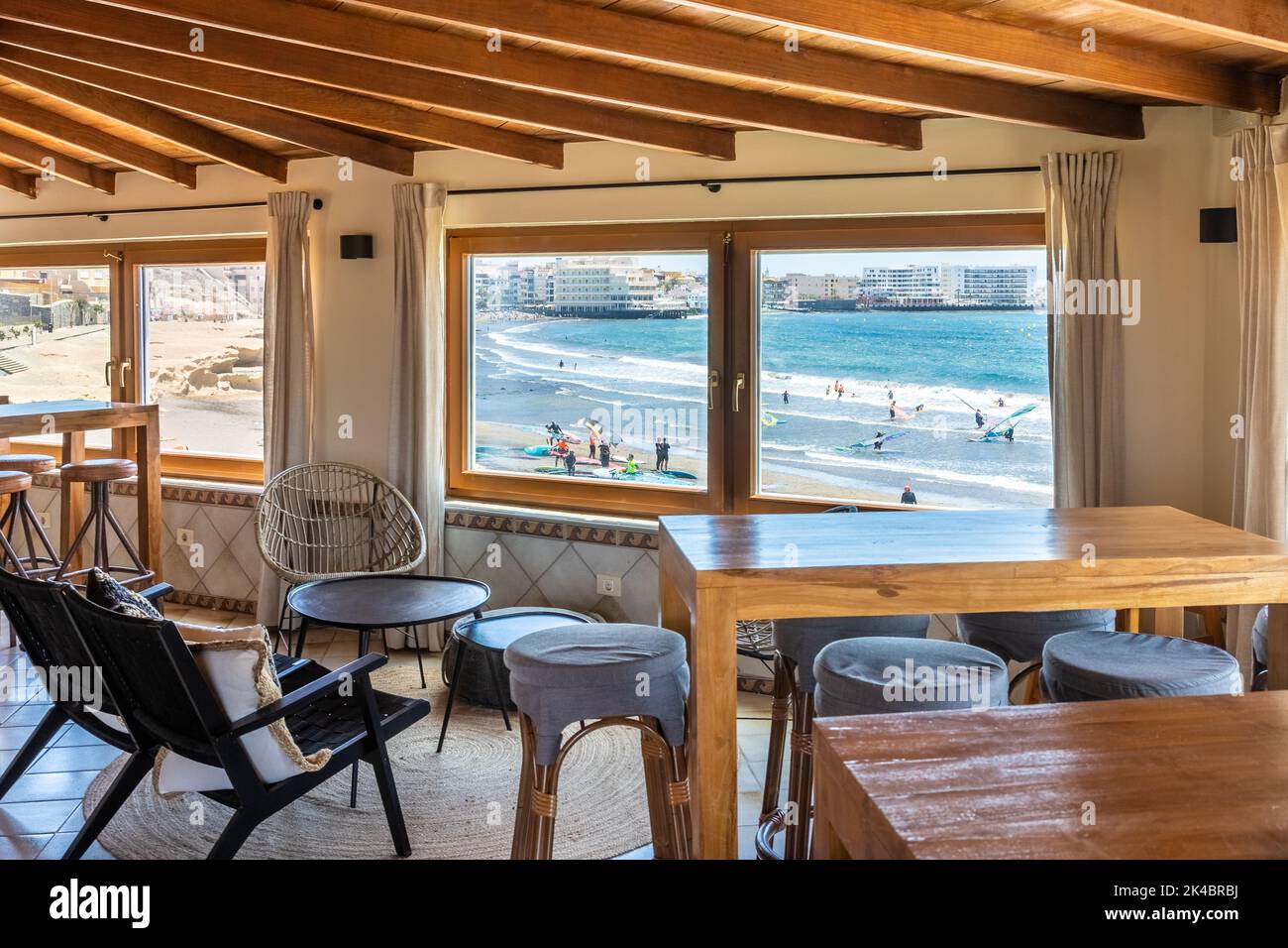 A shot of the inside of a cafe with chairs and tables with a window ...