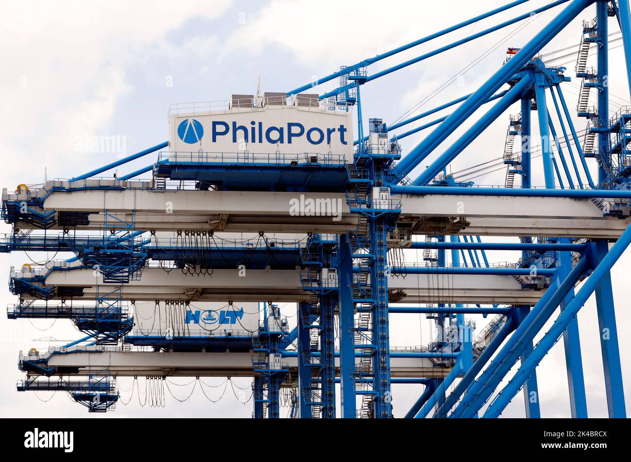 A row of massive cranes sit ready to offload incoming cargo ships at ...