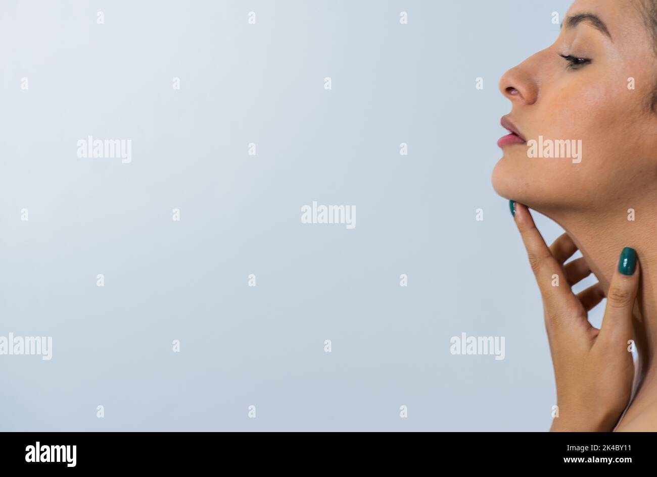 A portrait of a young Colombian female model posing touching her head ...