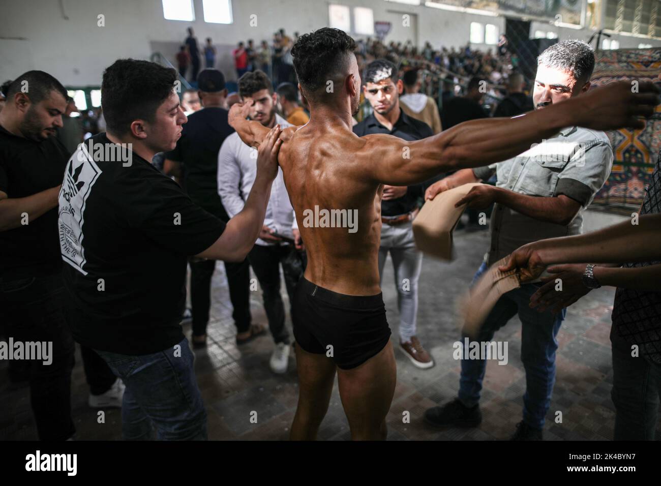 Gaza, Palestine. 01st Oct, 2022. A Palestinian man sprays body oil on ...