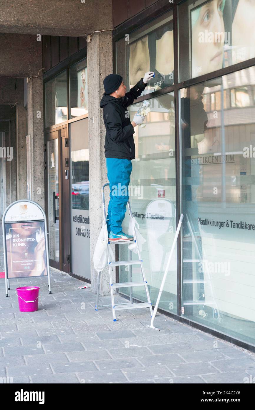 Man cleaning windows removing prints from window Stock Photo - Alamy