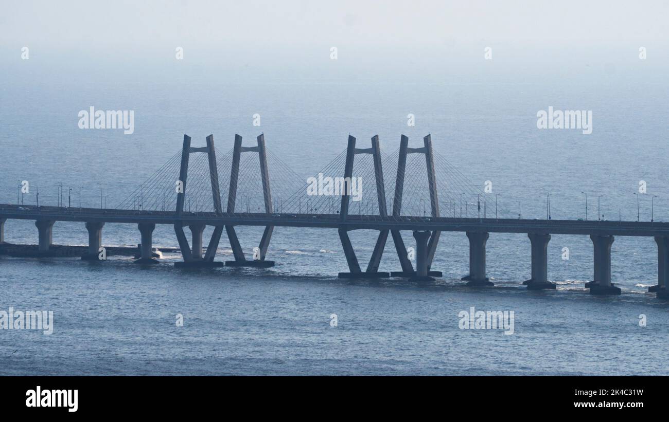 An aerial view of bridge over sea with cars driving on road in Bandra ...